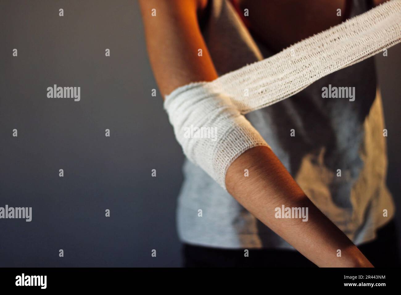 Woman putting a bandage on her arm Stock Photo - Alamy