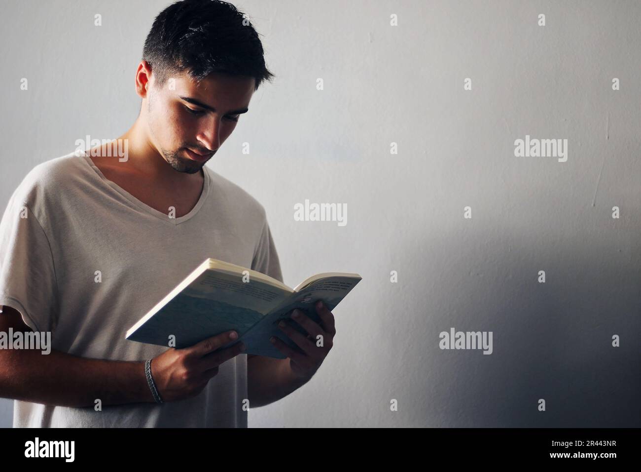 Man dressed in white reading a book Stock Photo - Alamy