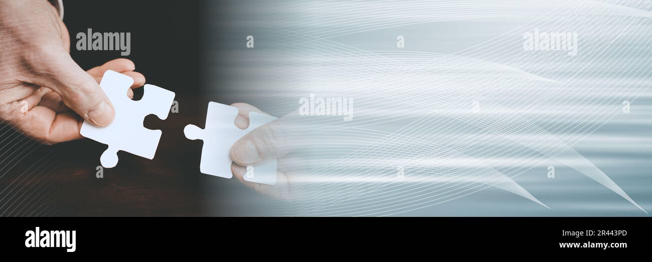 Hands joining two puzzle pieces, teamwork concept; panoramic banner ...