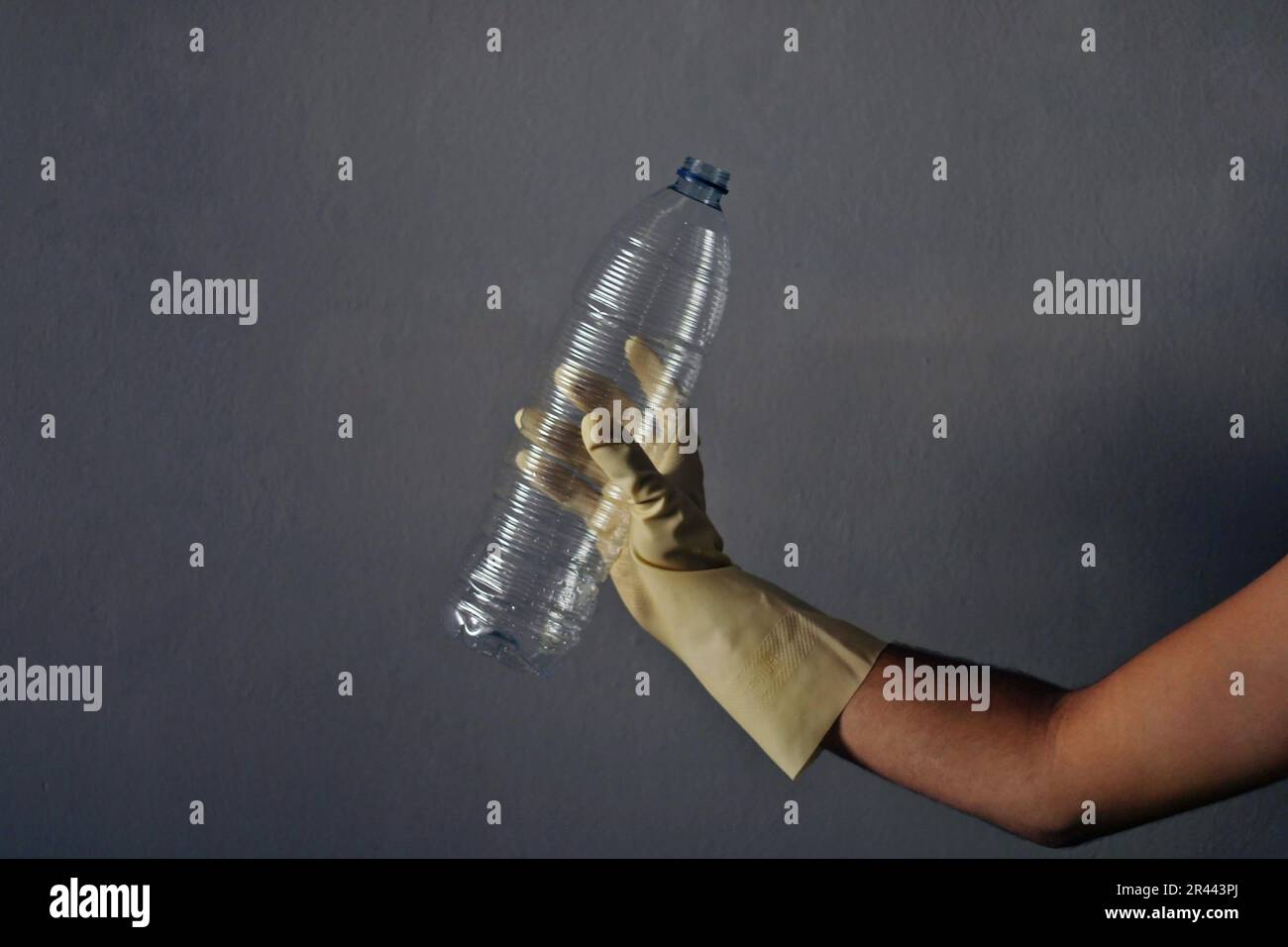 Man with gloves recycling a plastic bottle Stock Photo - Alamy