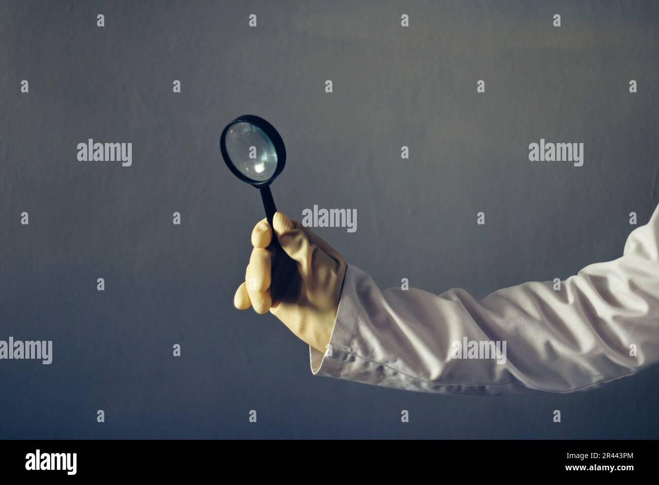Doctor with gloves and a magnifying glass on his hands Stock Photo - Alamy