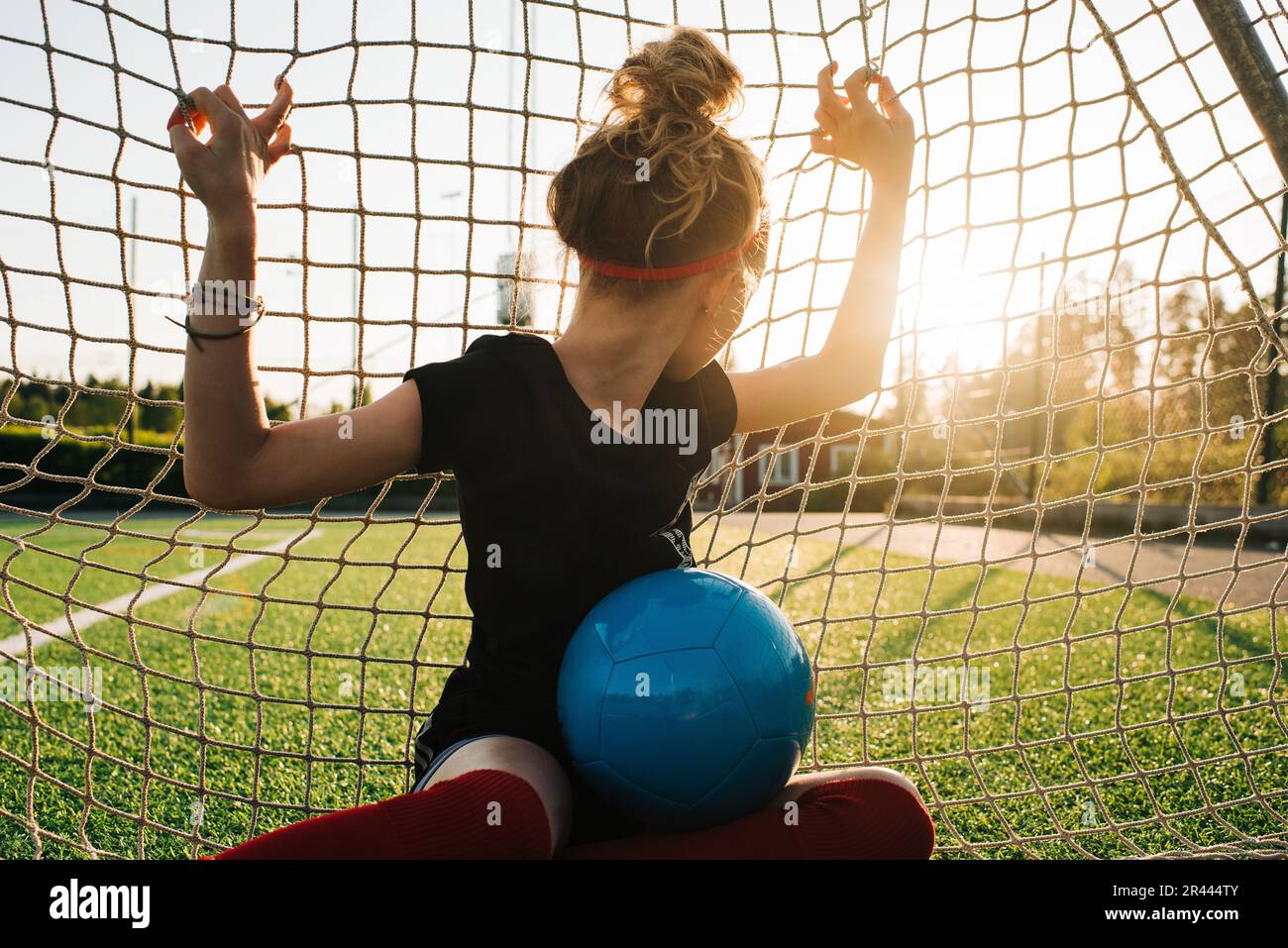 girl sat in a football goal looking away into the distance Stock Photo ...