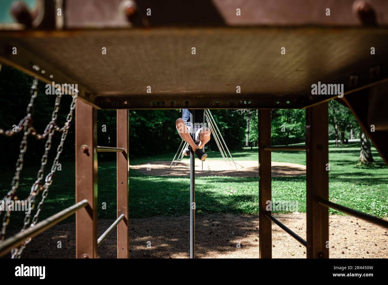 Faceless image of child climbing up pole on metal playground at Stock ...