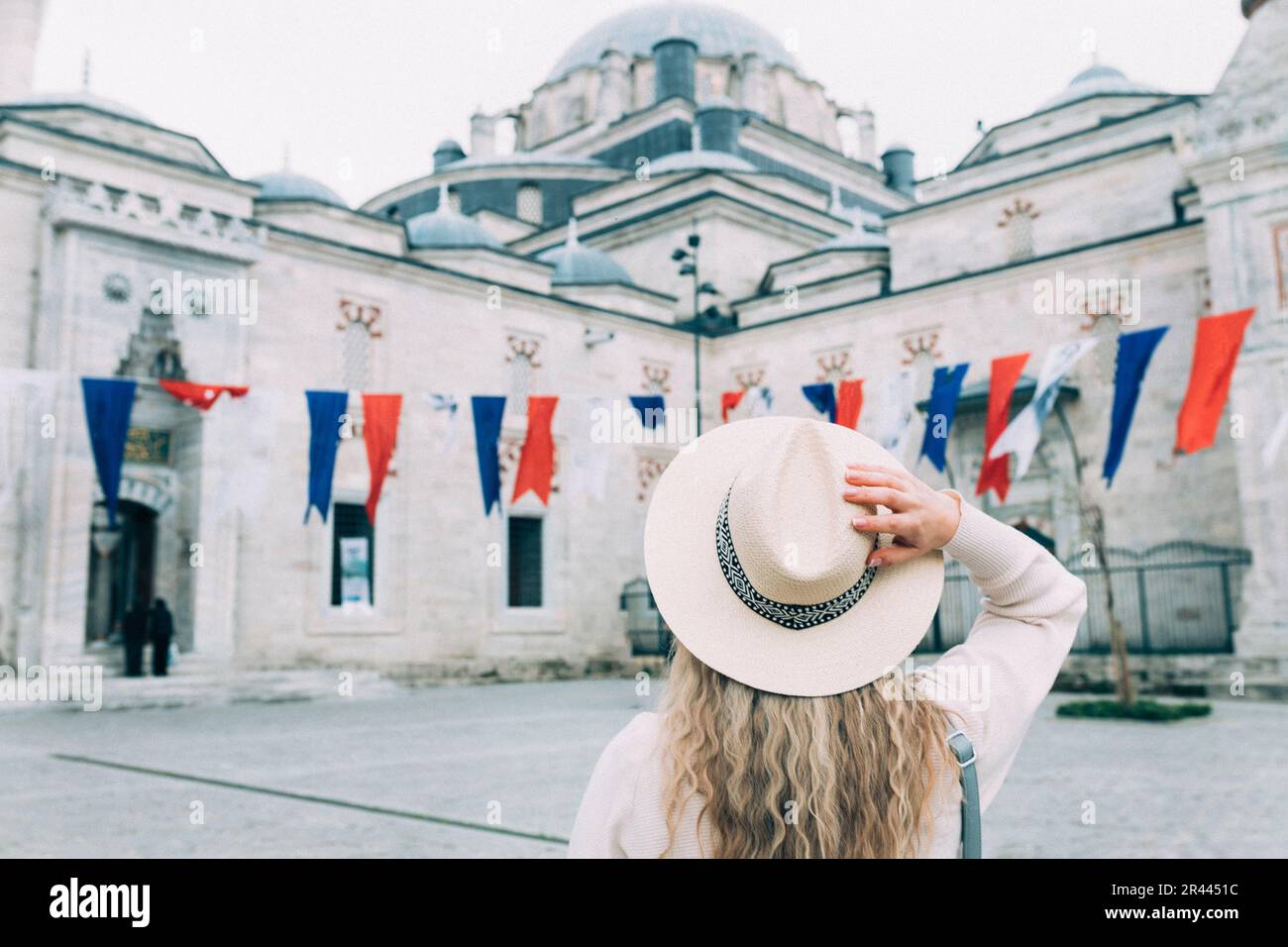 A woman tourist in a hat leads her friend to the Turkish mosque Stock ...