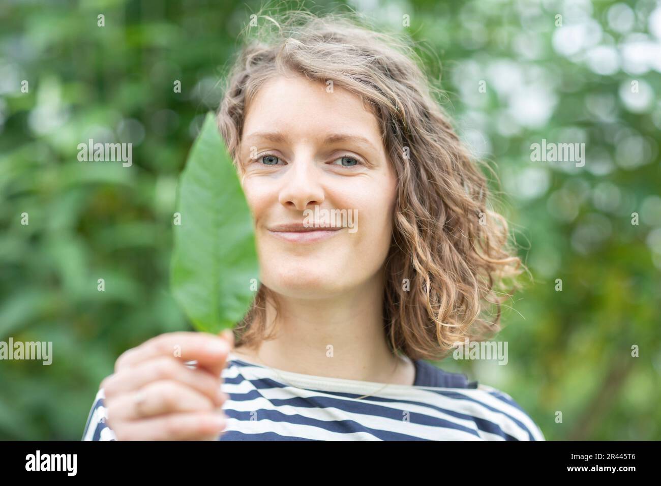 young woman with green leave in the hand Stock Photo - Alamy