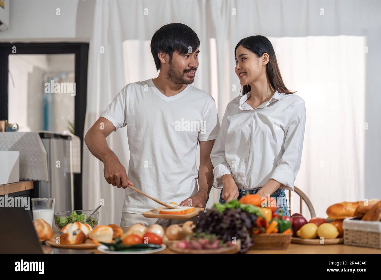 Happy smiling couple cooking together and healthy eating concept ...