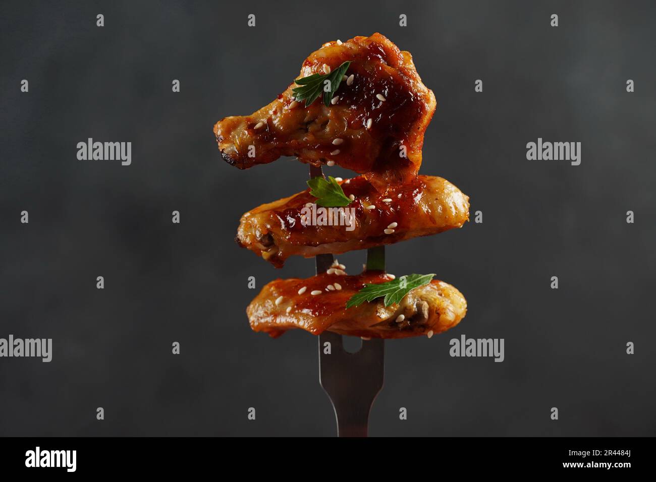 Fried barbecue chicken wings close up skewered on carving fork Stock ...