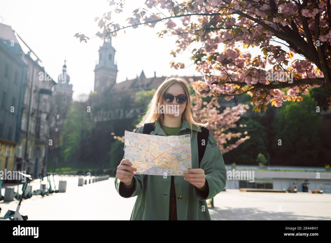 Young traveller woman walking on old town holding tourist map shows the ...