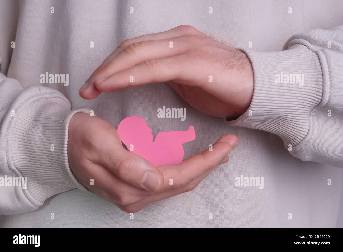 Female health. Man holding newborn paper figure, closeup Stock Photo ...