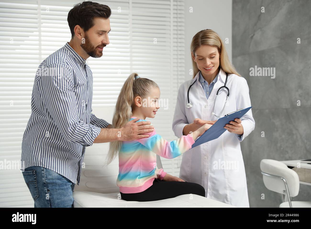 Father and daughter having appointment with doctor. Pediatrician ...