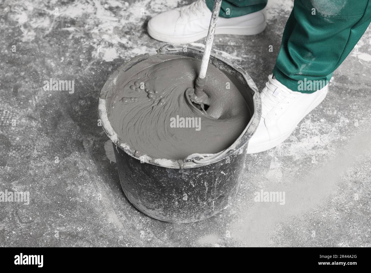 Person mixing cement in bucket hi-res stock photography and images - Alamy