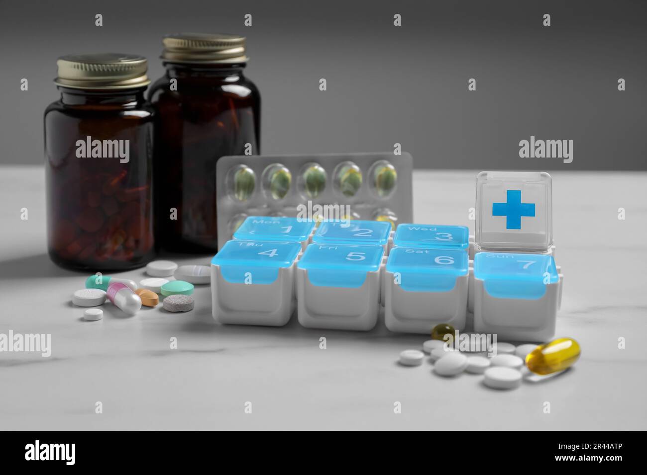Weekly pill box with medicaments on white marble table Stock Photo - Alamy