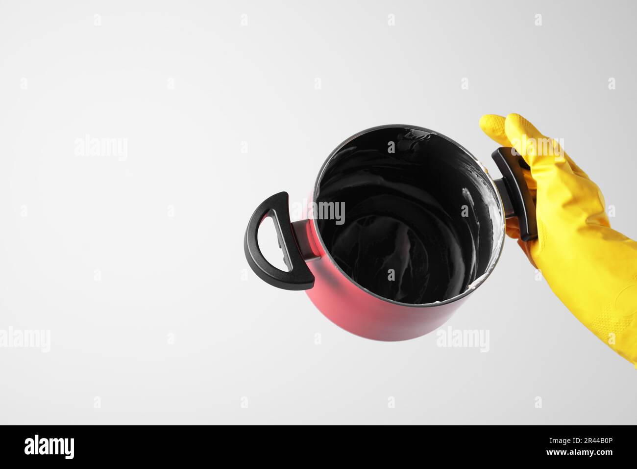 Woman holding dirty pot on white background, closeup. Space for text ...