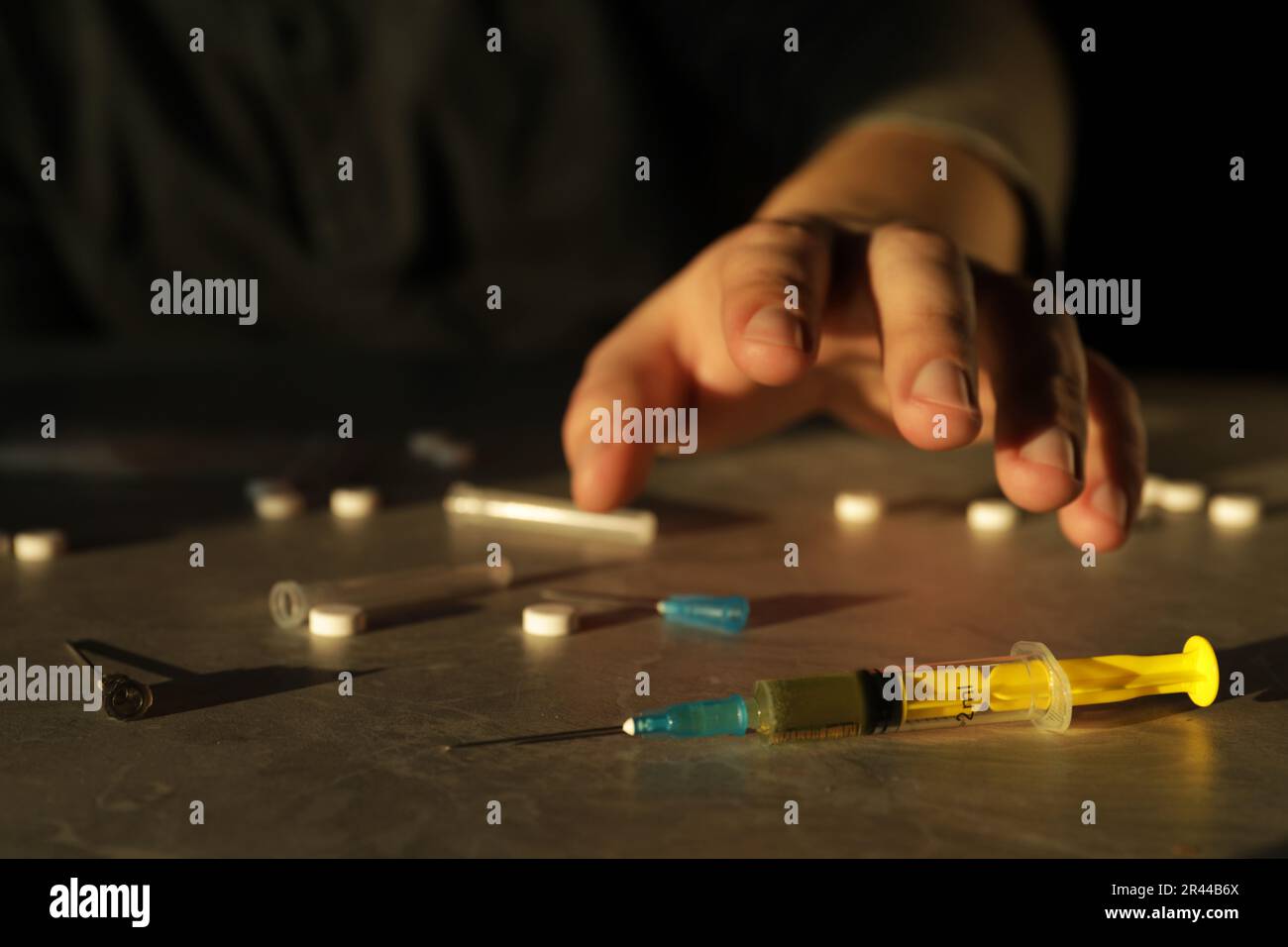 Addicted man near drugs at grey textured table, focus on syringe Stock ...
