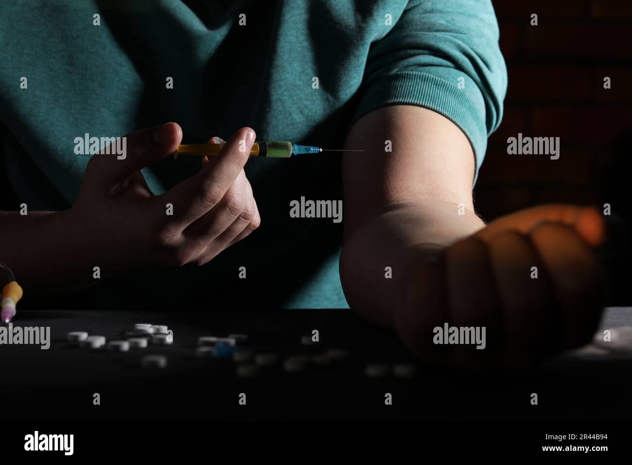 Addicted man taking drugs at black table, closeup Stock Photo - Alamy