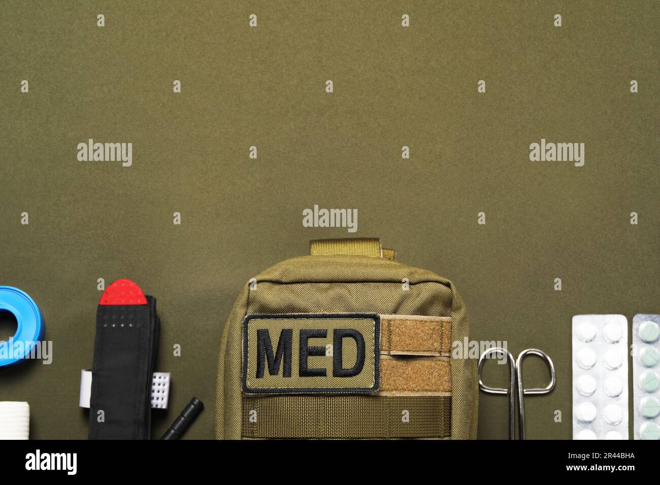 Flat lay composition with military first aid kit on khaki background ...