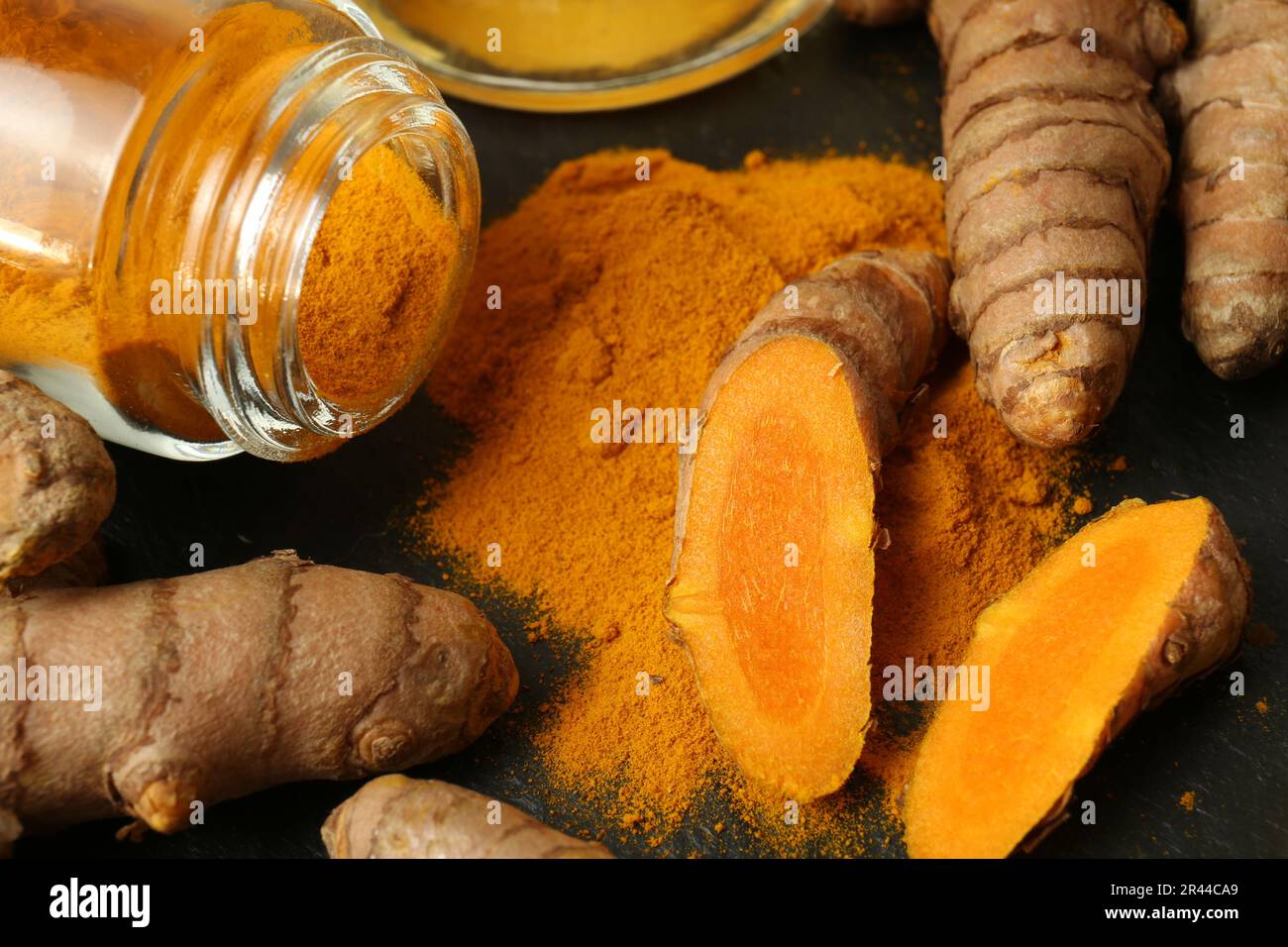 Turmeric roots and powder on black textured table, closeup Stock Photo ...