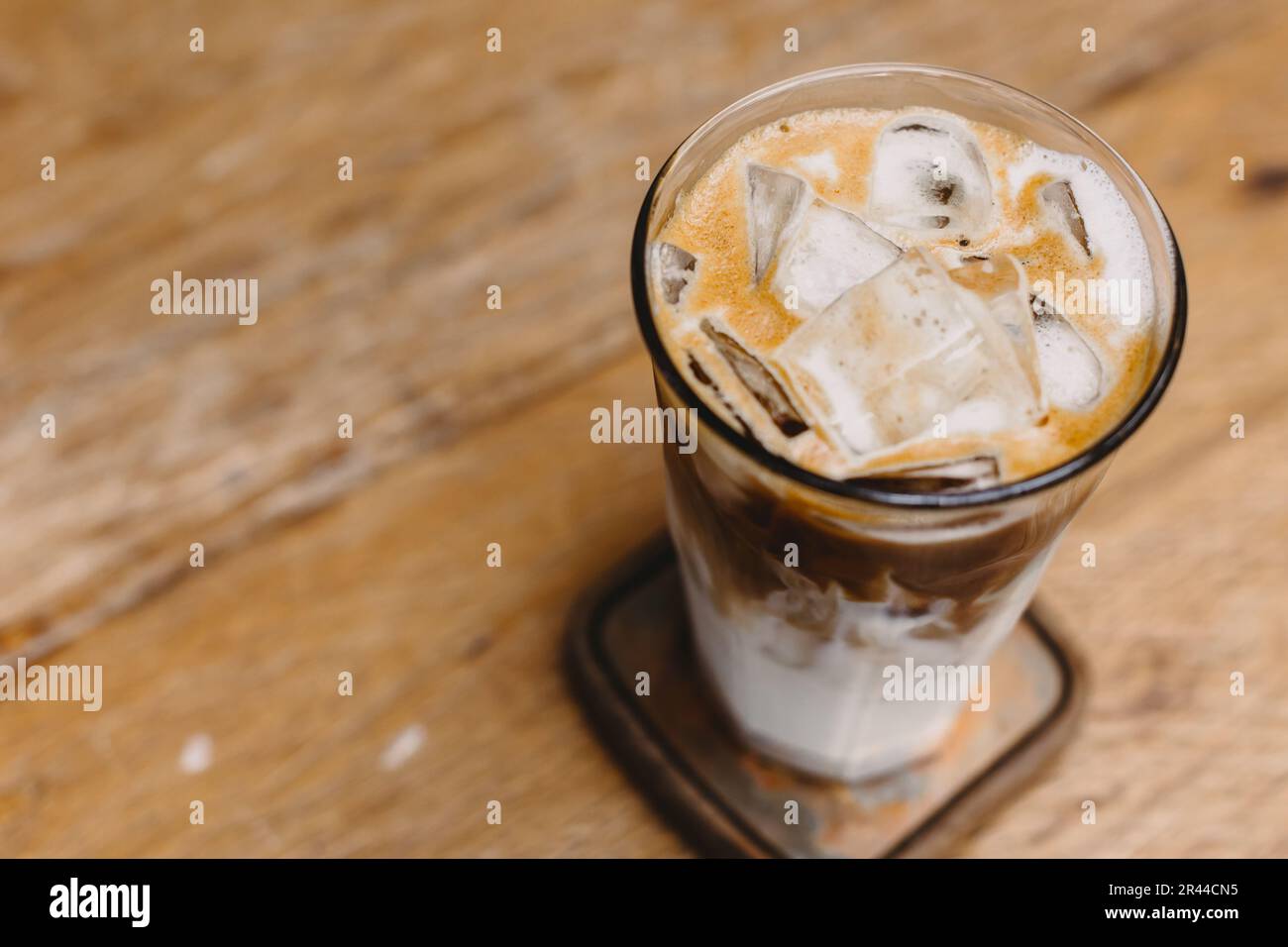 iced coffee, cold milk latte with ice on wood table background copy ...