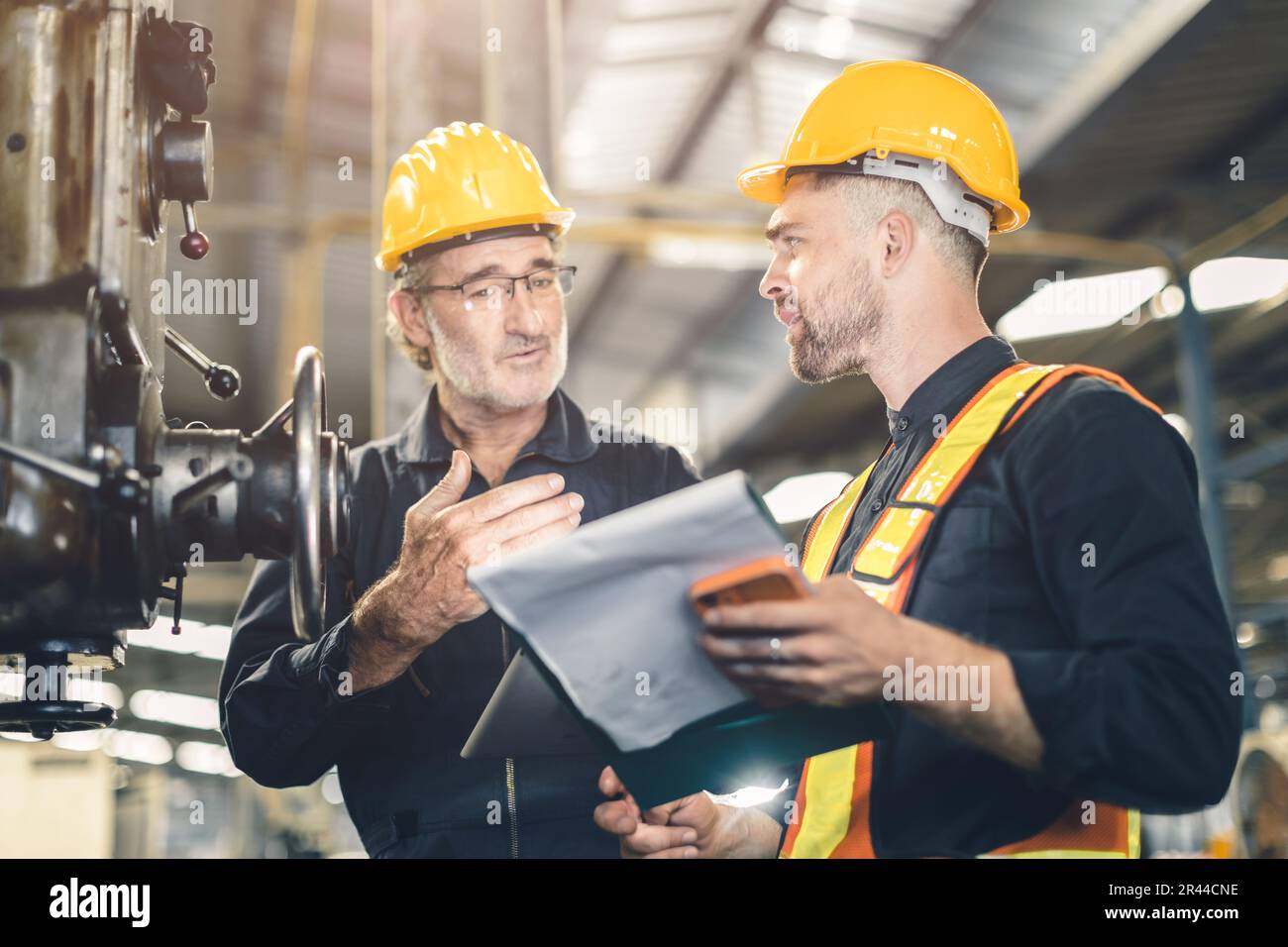 senior male worker training new young engineer employee working in ...