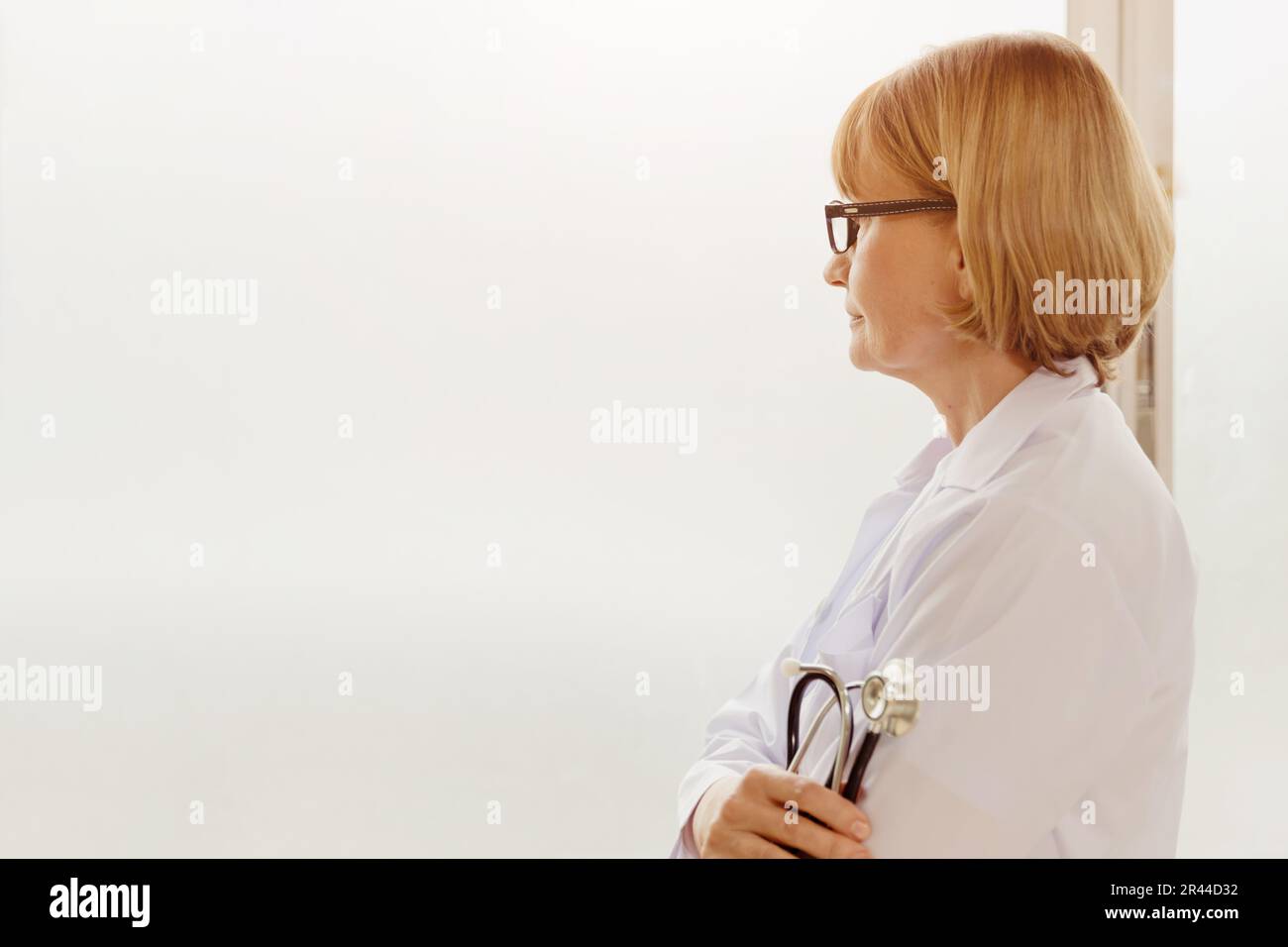 doctor stress. senior medical staff female with stethoscope looking out ...