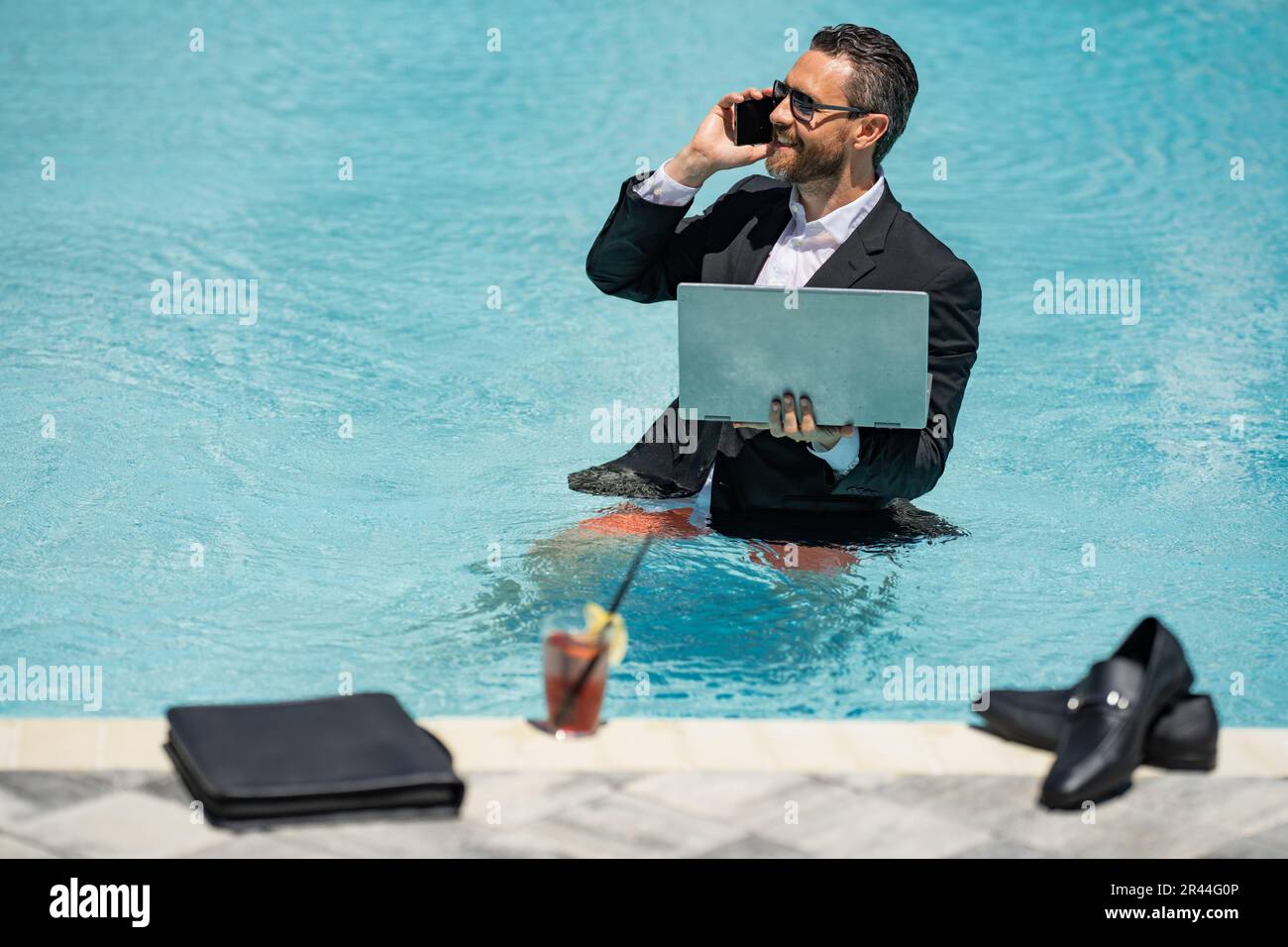 Businessman in suit with laptop in swimming pool. Crazy business man ...