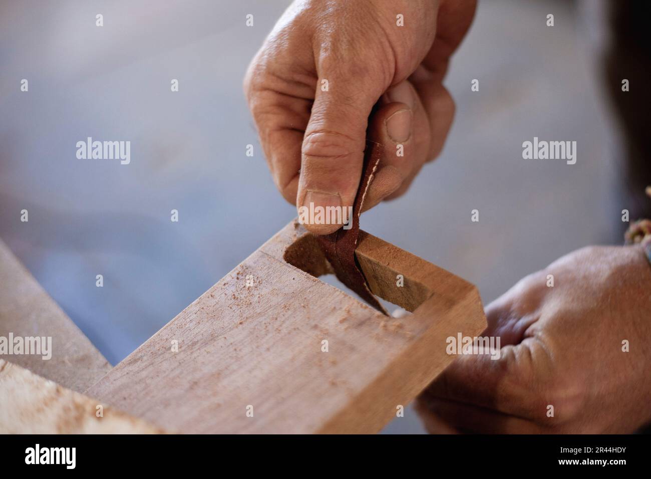 Capturing the skillful hands of a woodworker meticulously sanding and ...