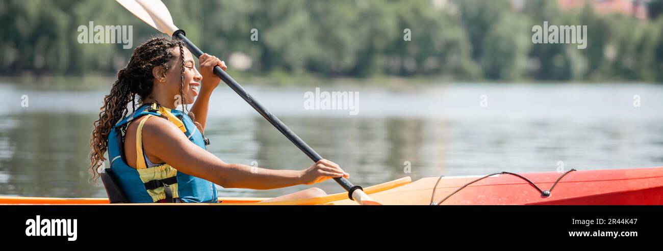 side view of active and happy african american woman in life vest ...