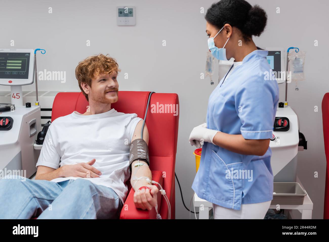 multiracial nurse in medical mask and latex gloves talking to positive ...