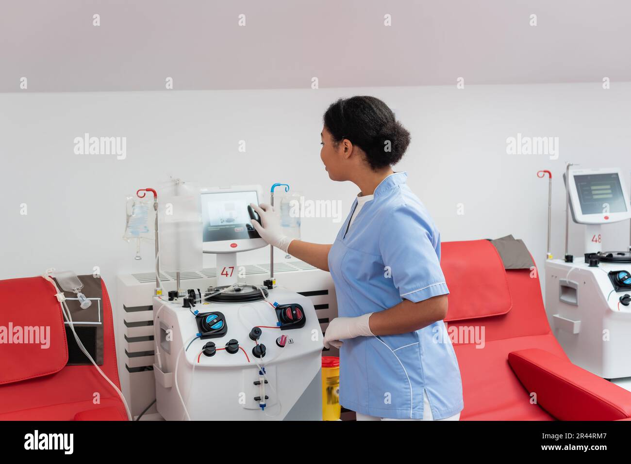 young multiracial doctor in blue uniform and latex gloves operating ...