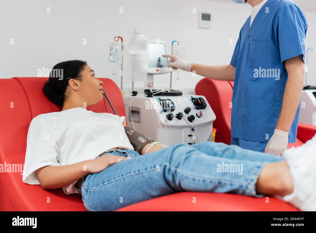 healthcare worker in blue uniform and latex gloves operating automated ...