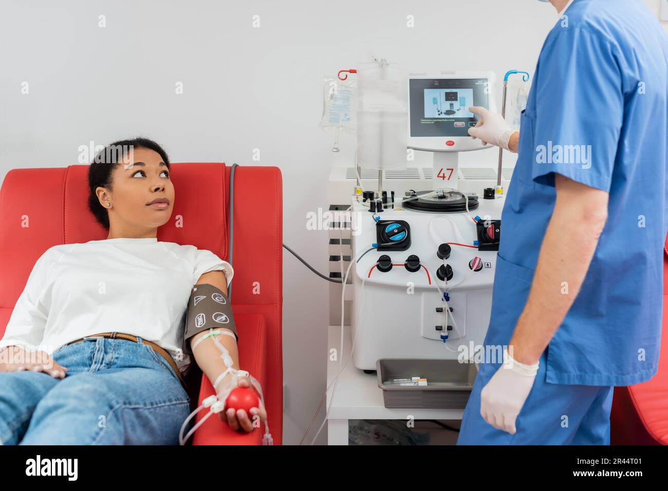 doctor in blue uniform and latex gloves operating transfusion machine ...