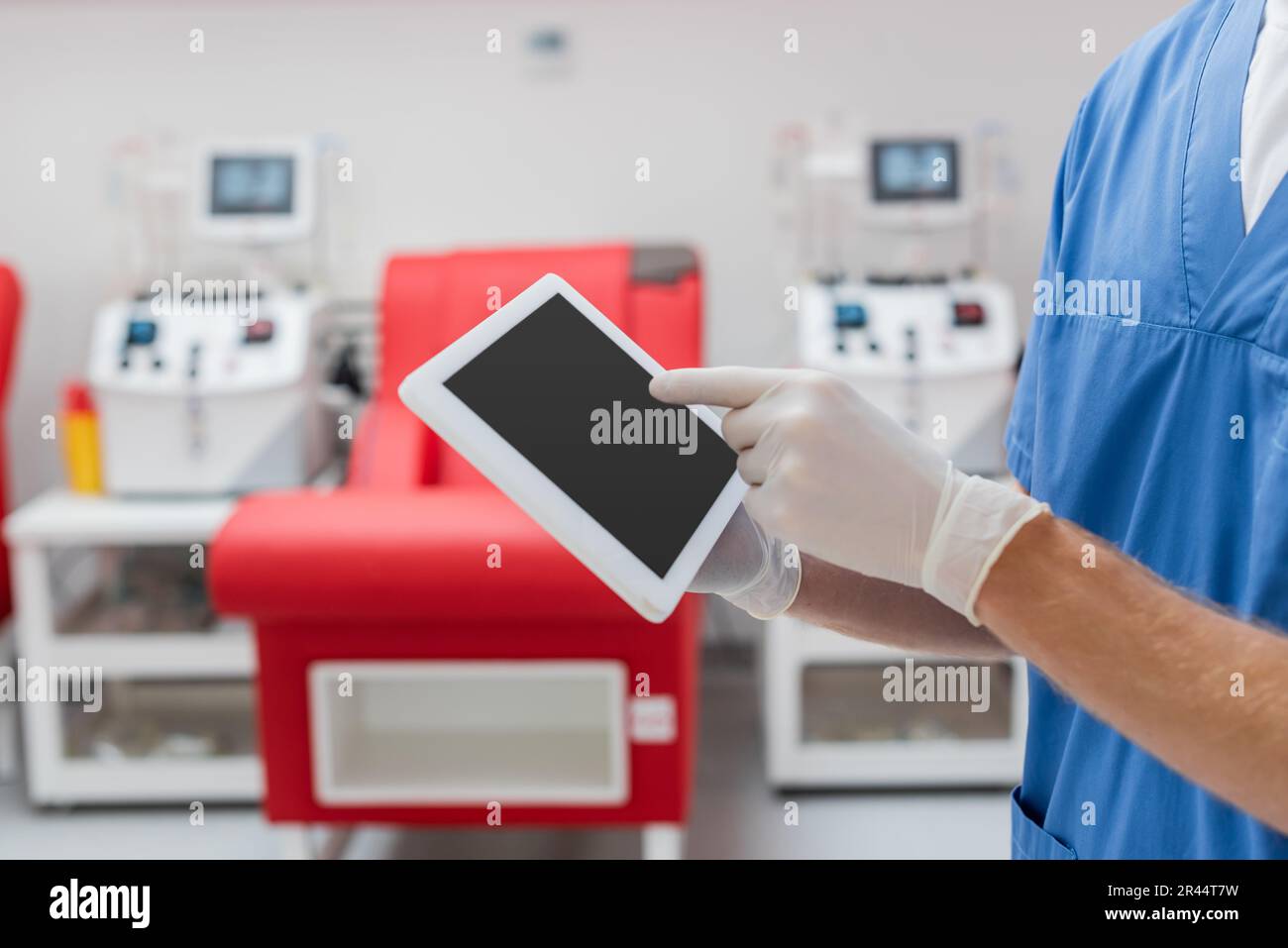 partial view of doctor in latex gloves pointing at digital tablet with ...