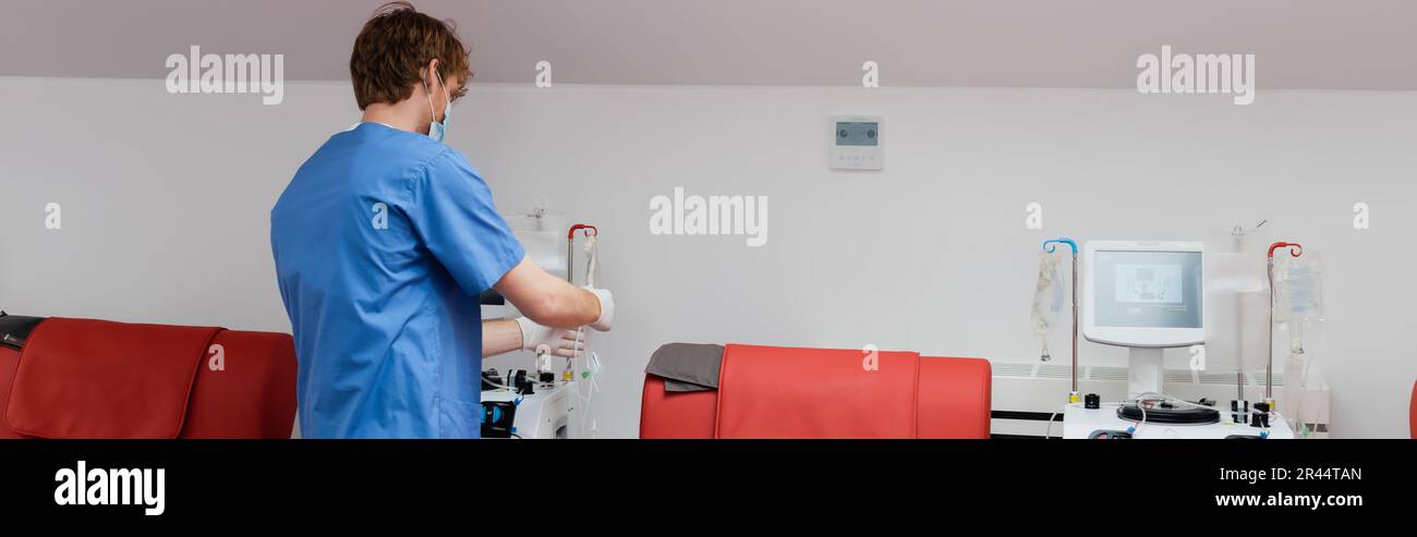 back view of redhead doctor in blue uniform, medical mask and latex ...
