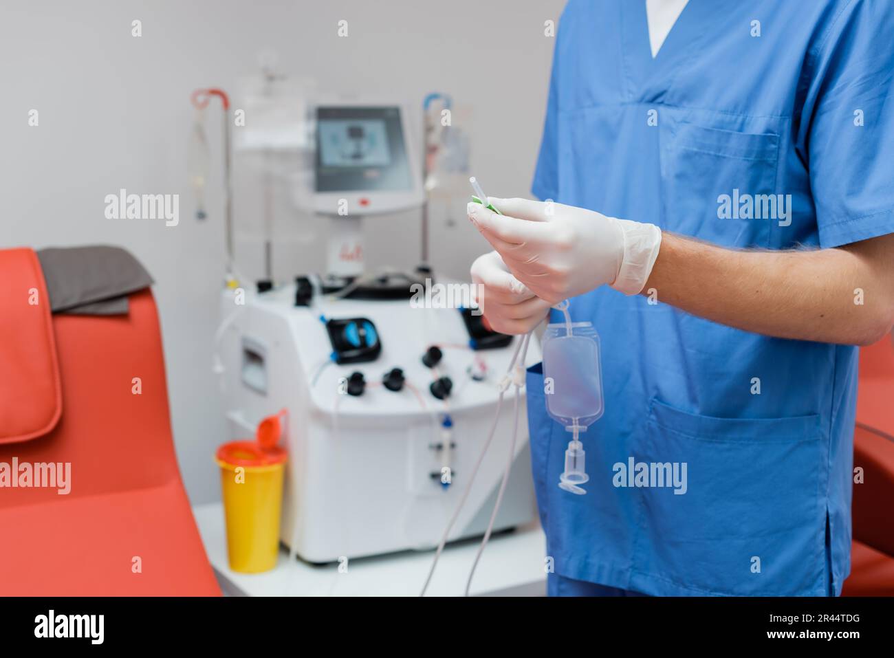cropped view of doctor in blue uniform and sterile latex gloves holding ...