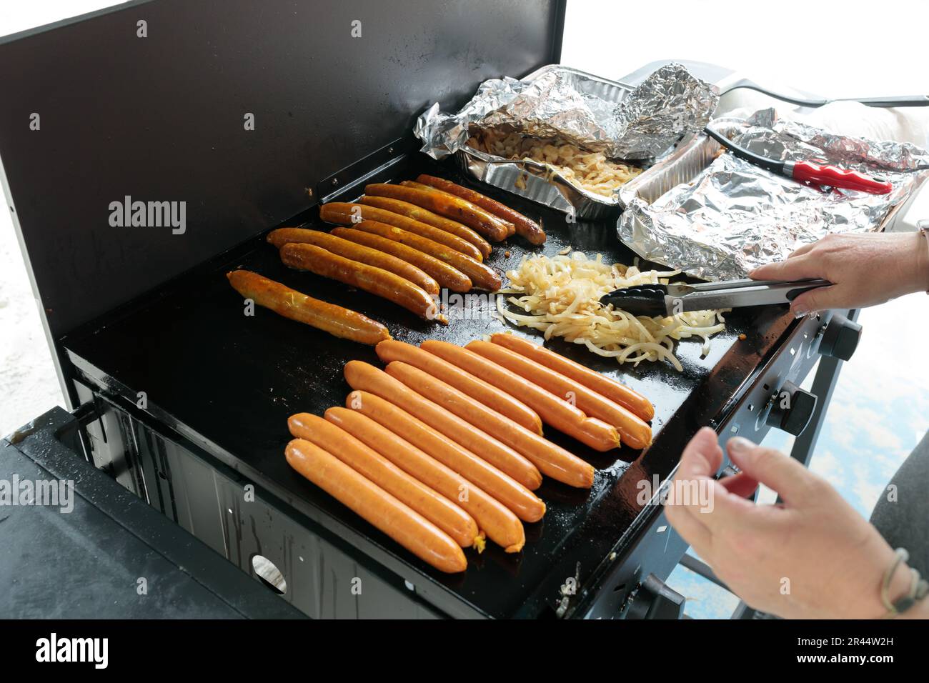 An unrecognisable person cooking a traditional australian bbq sausage ...