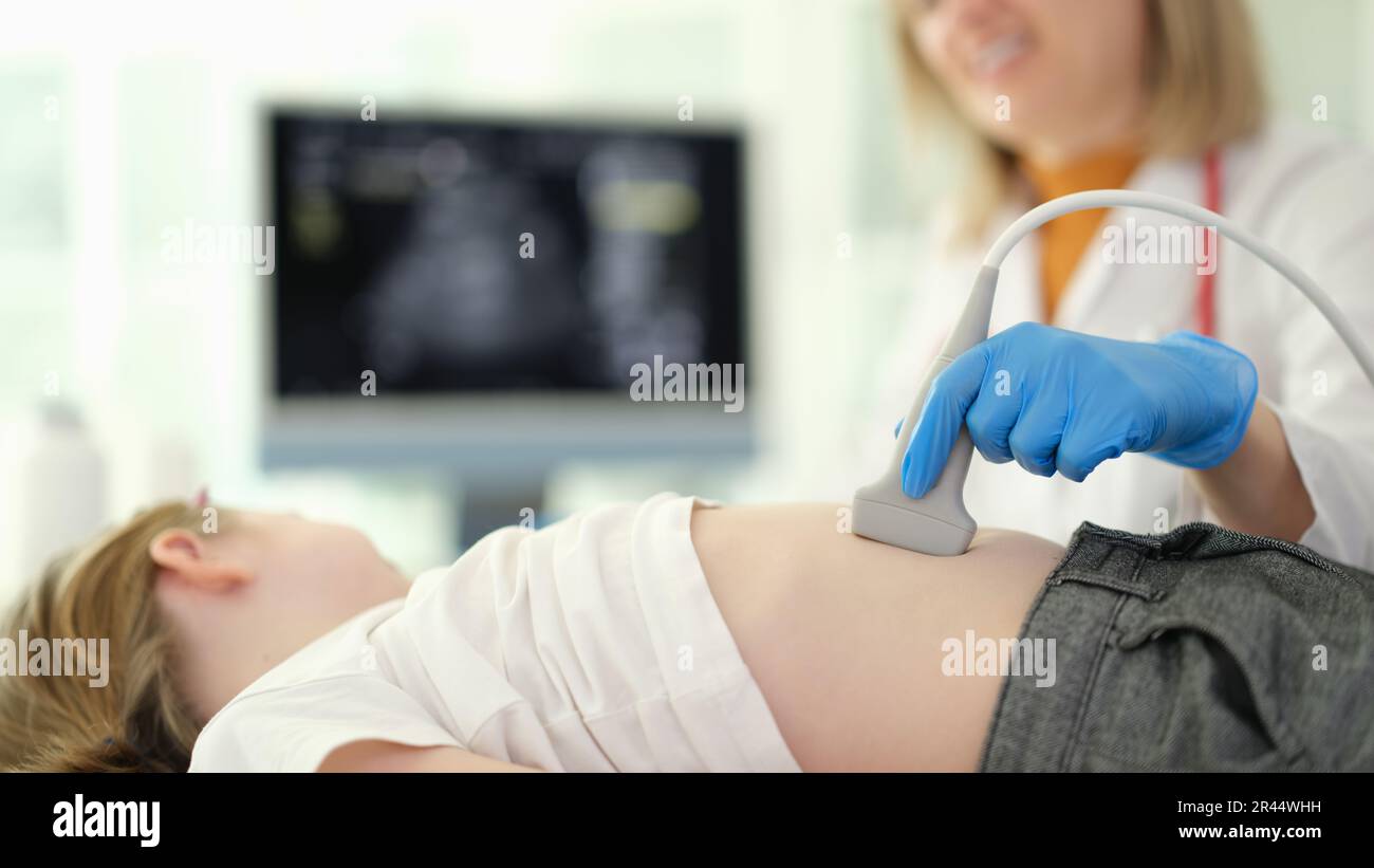 Doctor conducting abdominal ultrasound examination of internal organs ...
