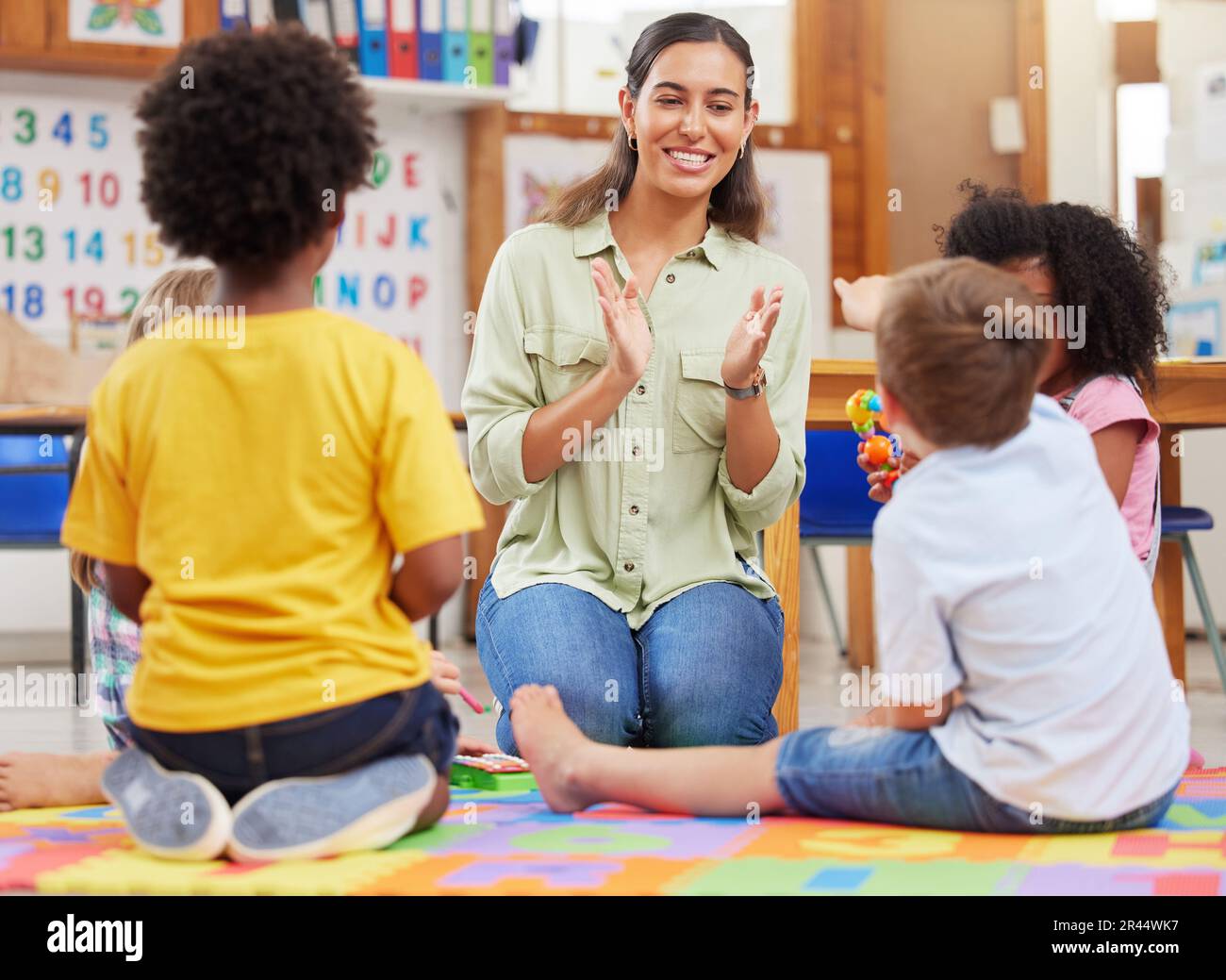 Diversity, teacher with children at school and playing together in a ...