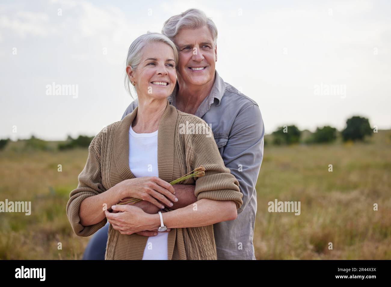 Love, hug and happy with old couple in nature for bonding, smile and romance. Happiness ...
