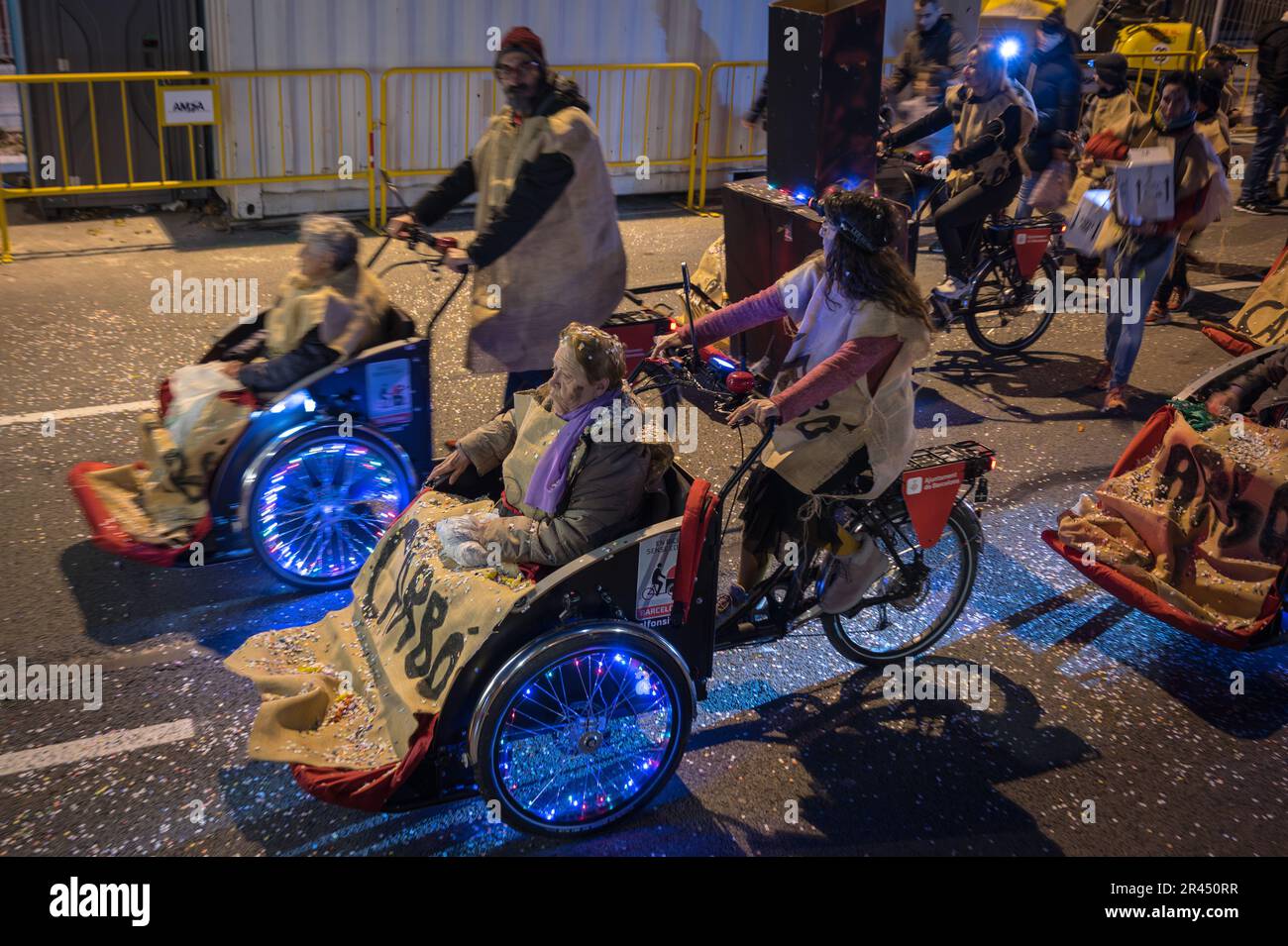 Grandmother riding the basket of the tricycle throwing candies and coal ...