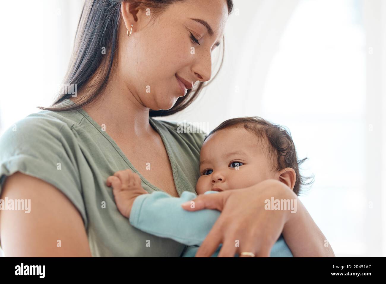 Mother holding baby in arms for love, care and quality time together to ...