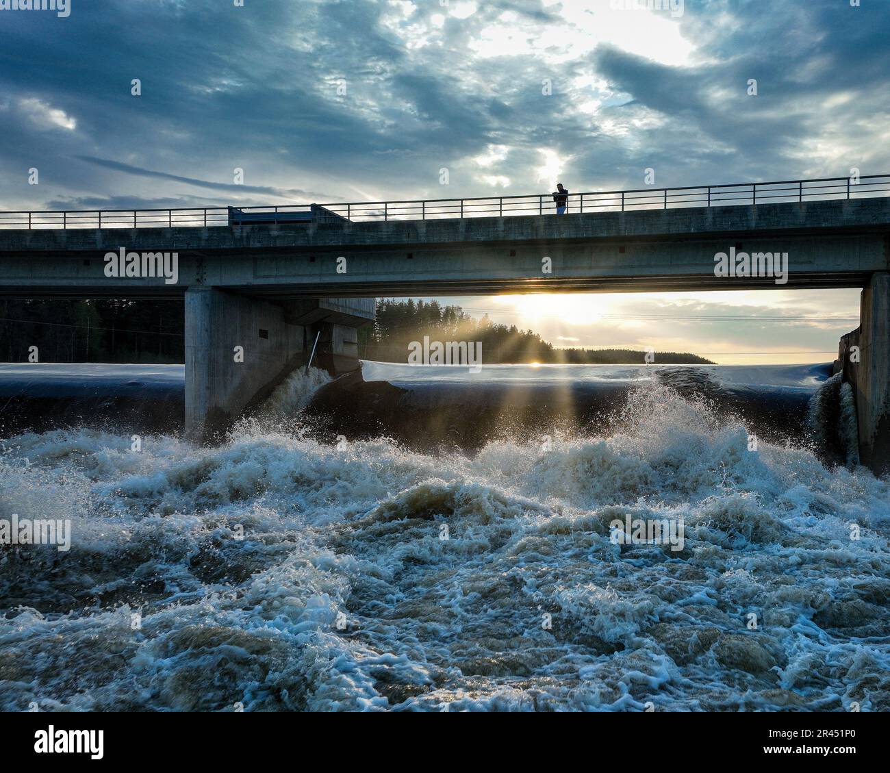 A scenic view of a bridge spanning a river with rippling waves below ...