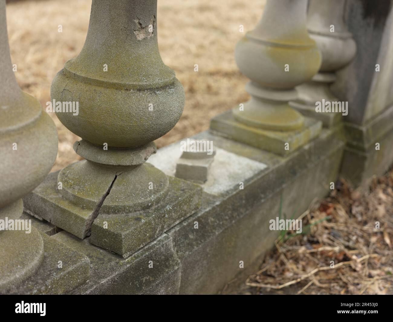 Three weathered stone pillars with moss and foliage growing around them ...