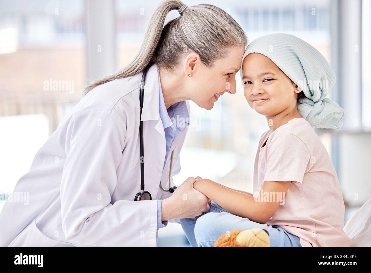 Smile, pediatrician and child holding hands on bed in hospital for ...