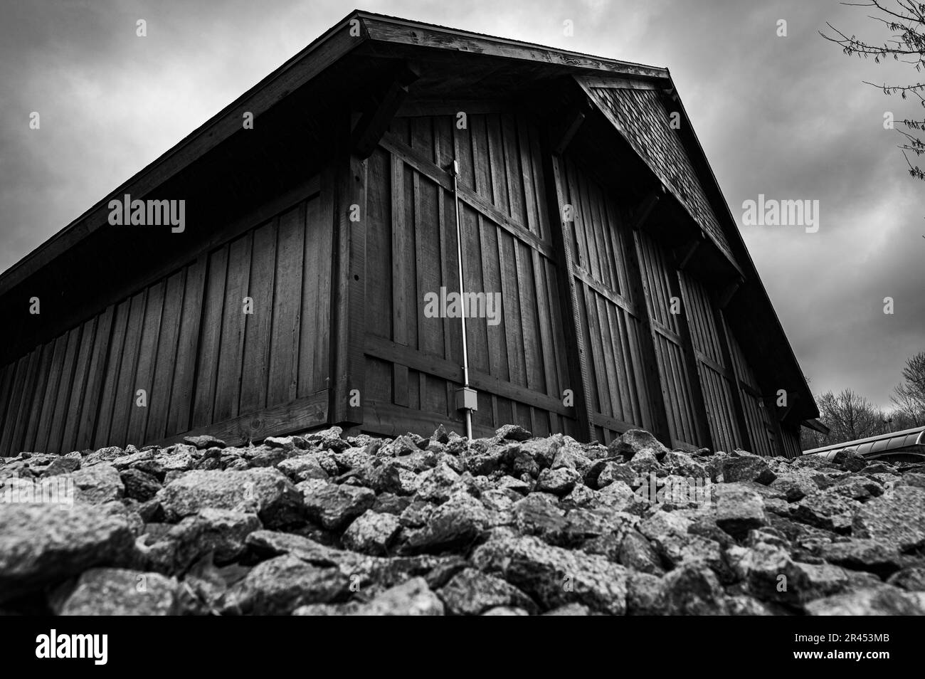 A low angle of a rural barn against a cloudy sky in grayscale Stock ...