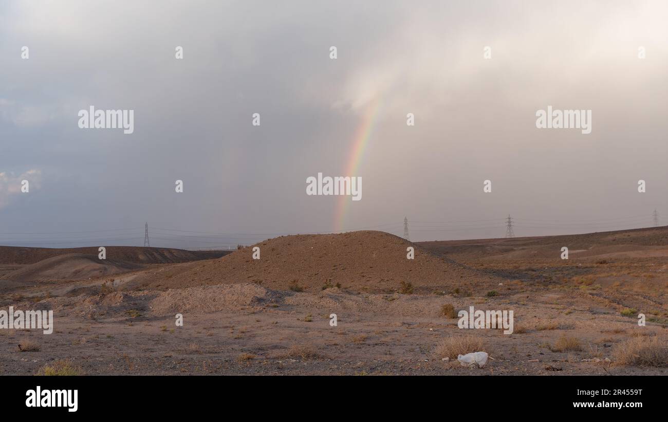 A breathtaking view of a vibrant rainbow arching over a rolling hill in ...