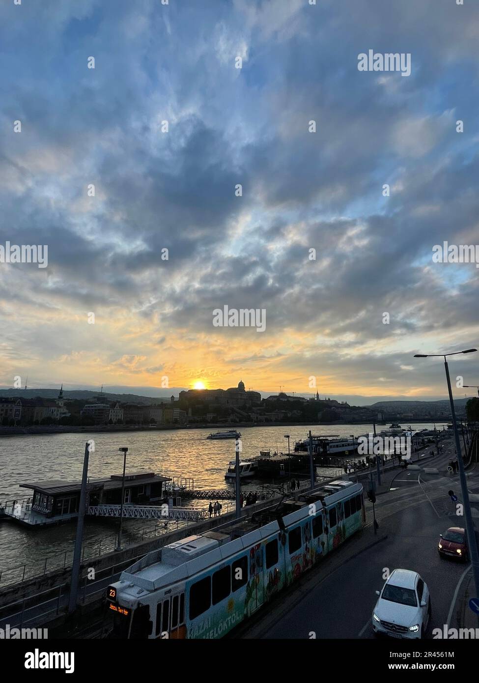 A commuter train advancing along the tracks that line the banks of a ...