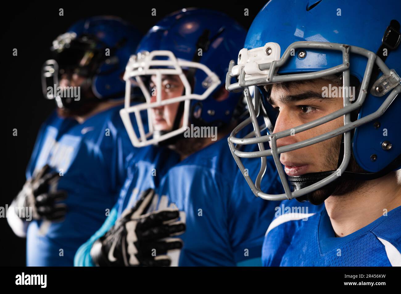 Portrait of three men in blue uniforms for American football with a ...