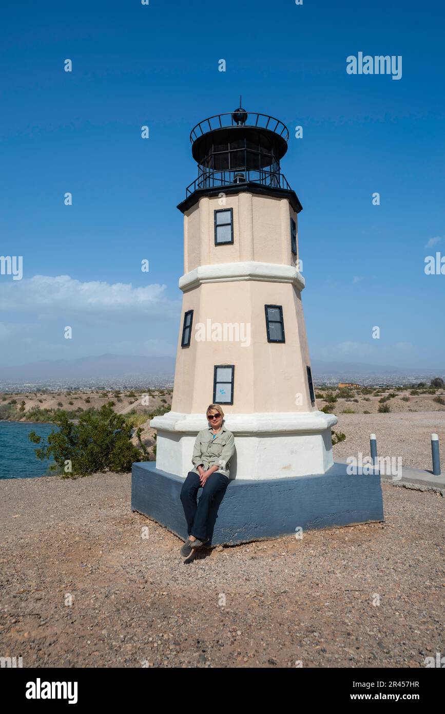 A woman sits beside a replica of the Split Rock Lighthouse on a windy ...