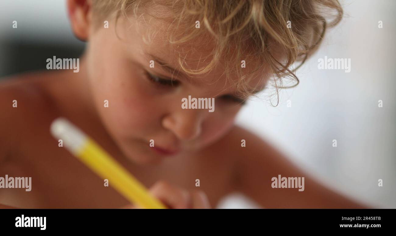 Artistic kid drawing on paper with yellow color pen. Focused ...