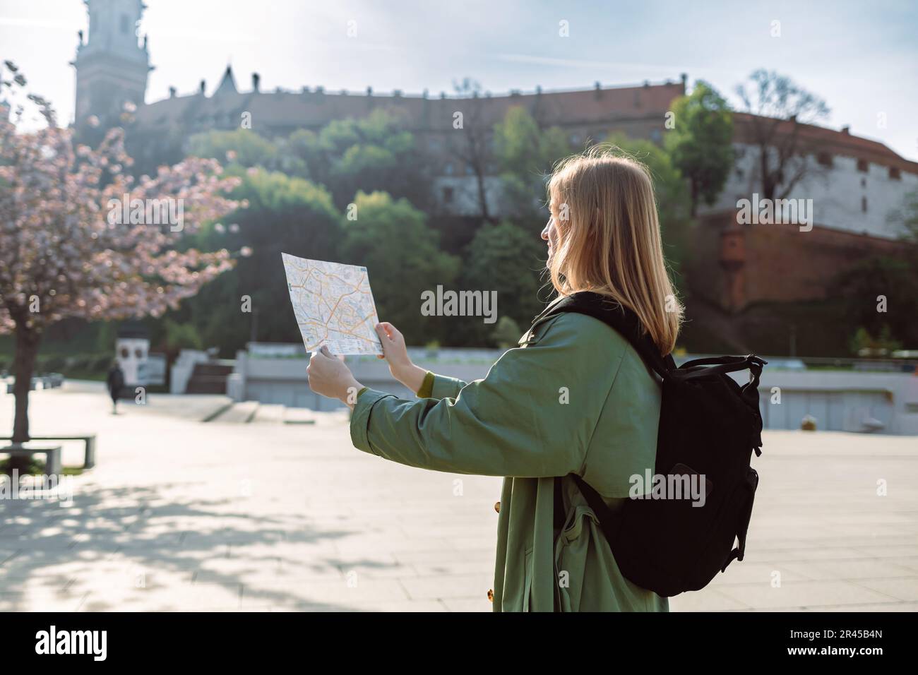 Young traveller woman walking on old town holding tourist map shows the ...